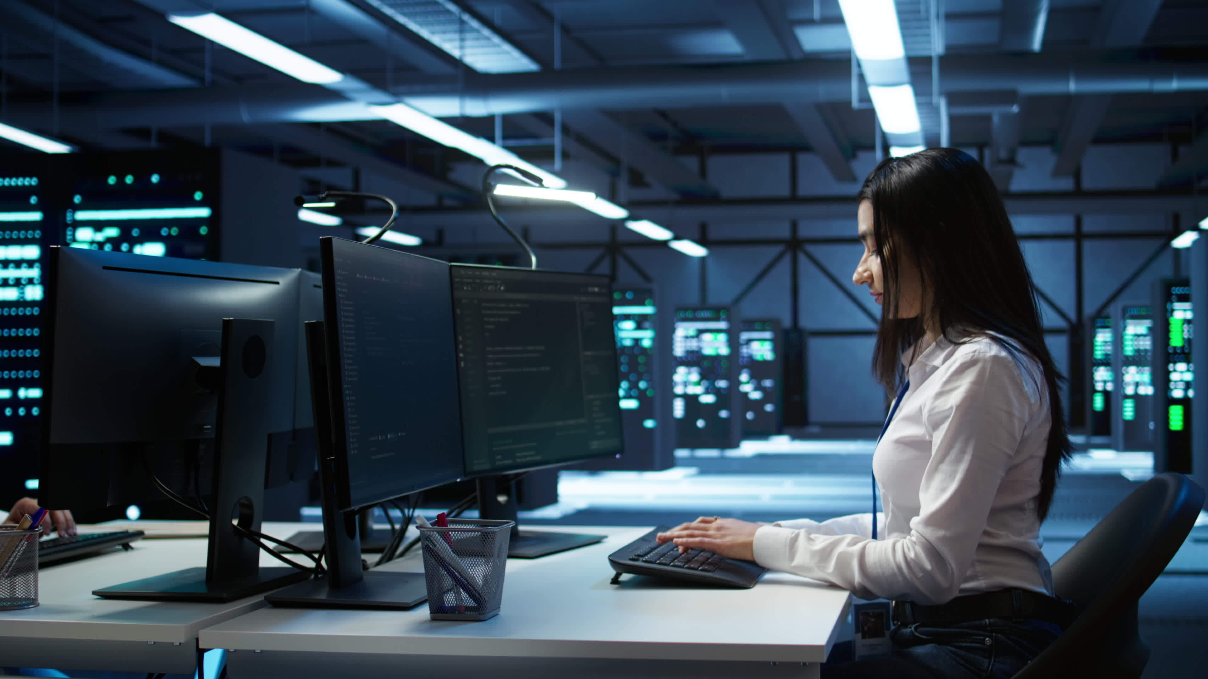 Portrait Of Smiling Engineer Overseeing Data Center Making Improvements And Updates To Ensure