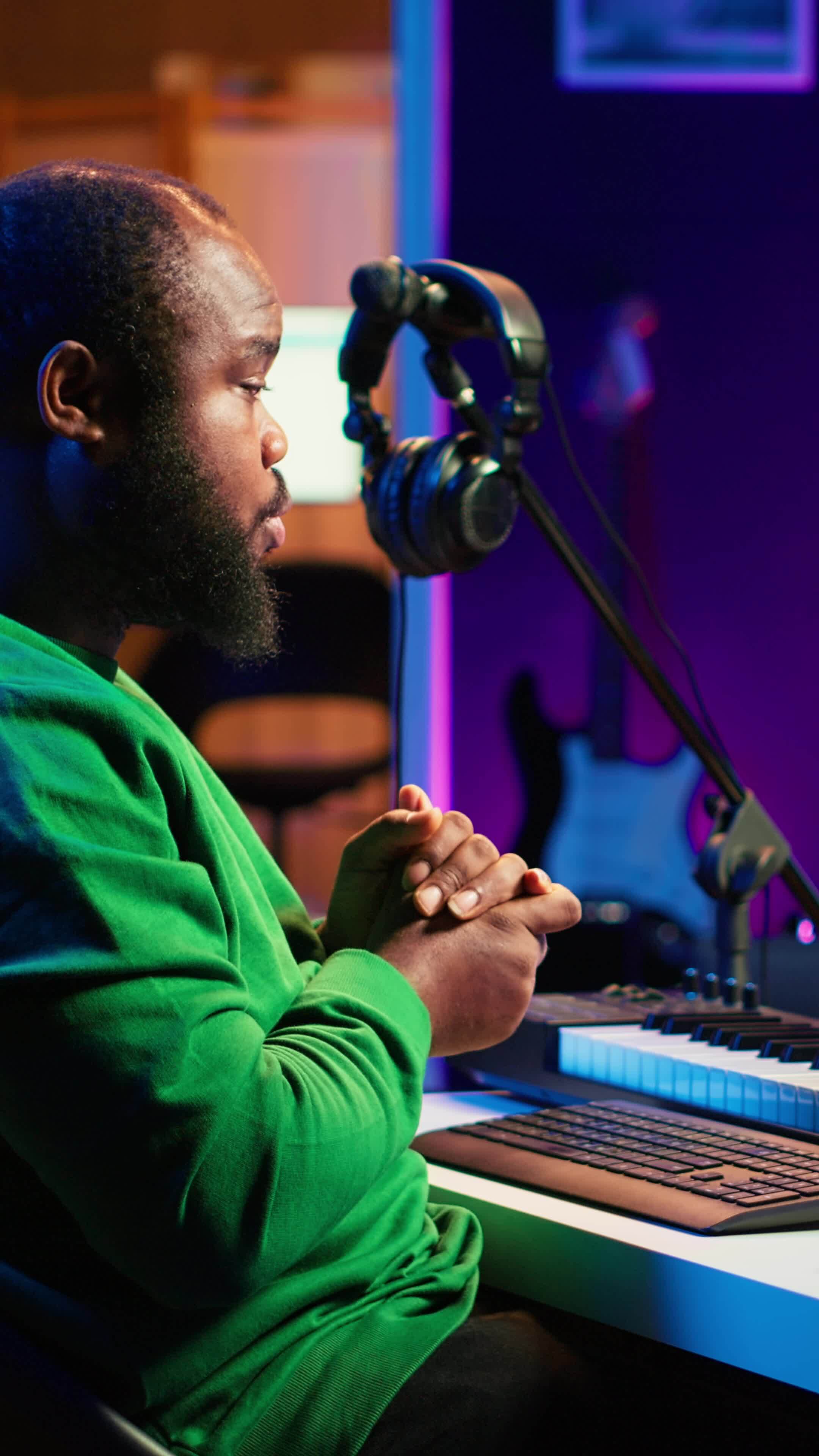 Vertical African American Sound Engineer Using Midi Controller Notes To
