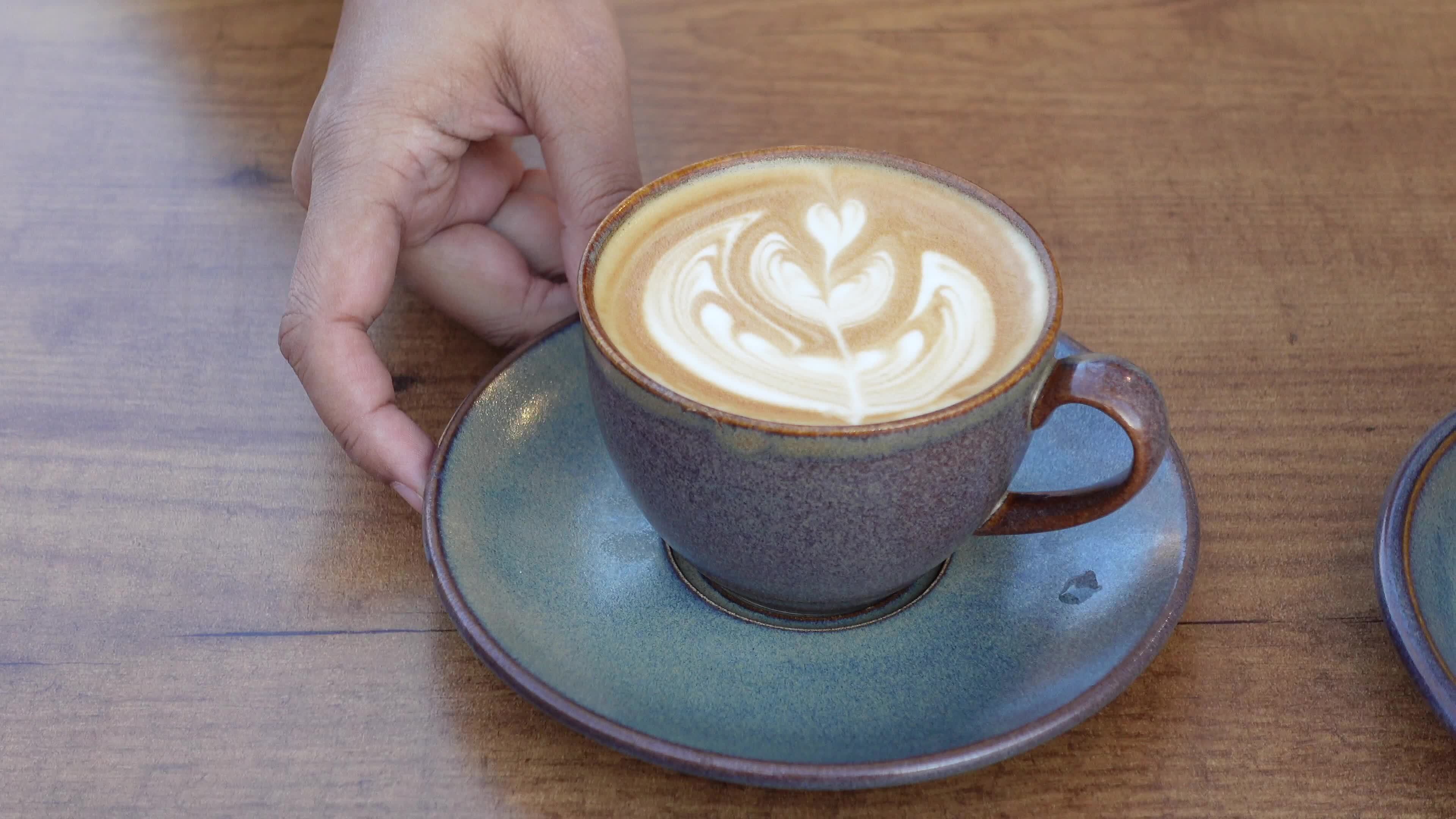 A beautifully crafted Artisan Coffee with intricate Latte Art on a rustic Wooden Table 48869602 ...