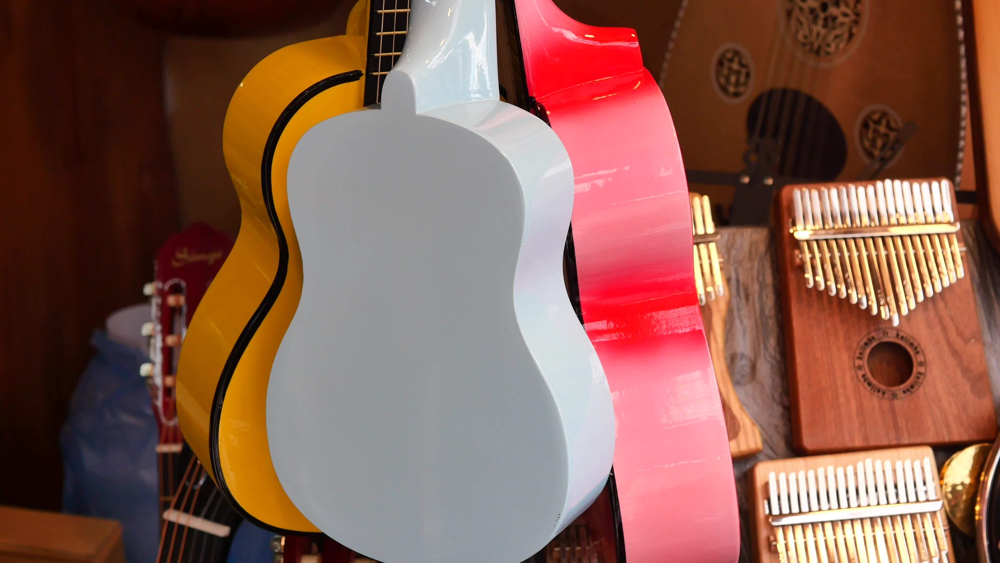 Row of colorful guitars hanging 48895876 Stock Video at Vecteezy