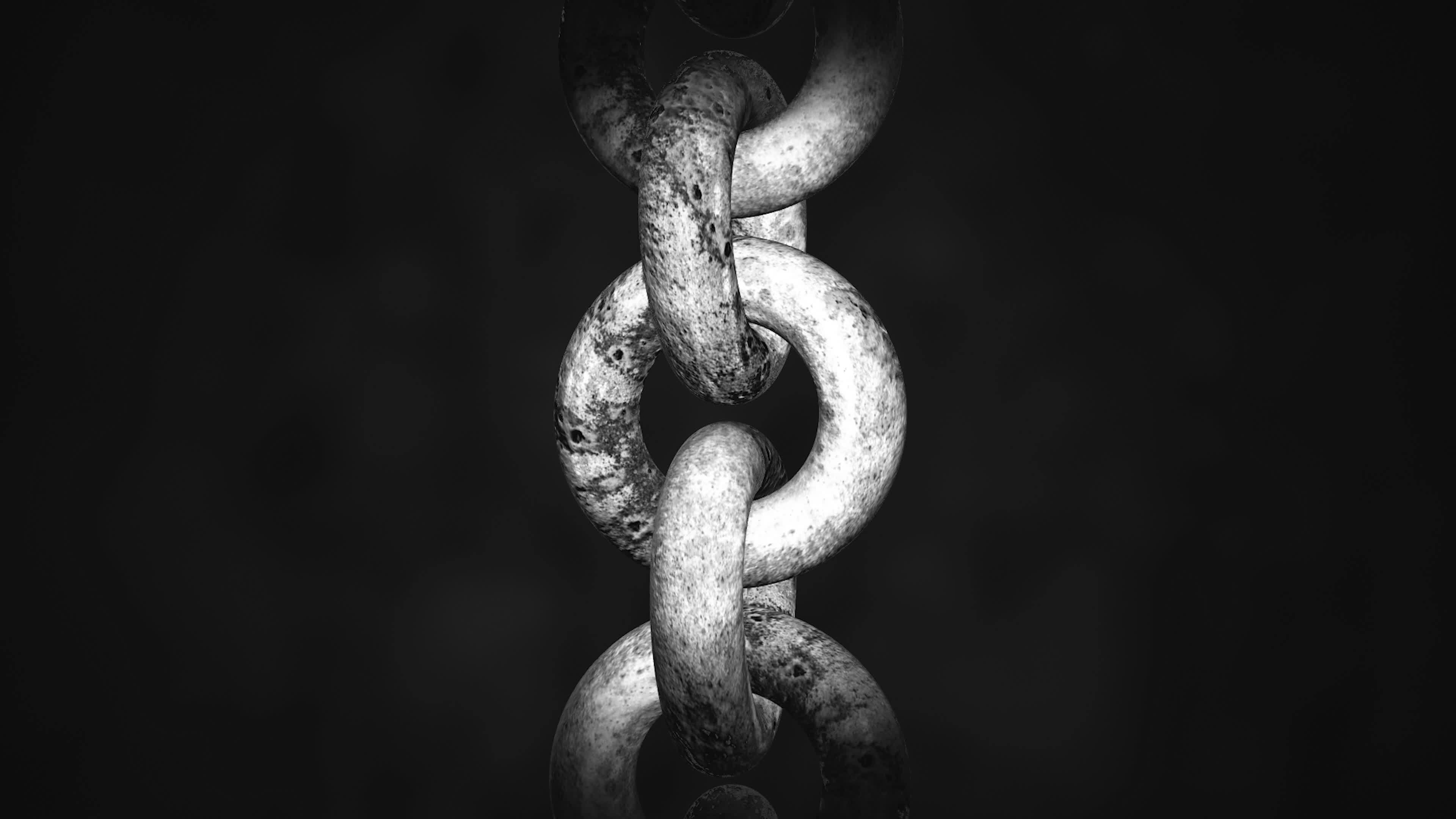Close up of hanging old rusty chain isolated on a black background. Motion. Rotating old chain ...