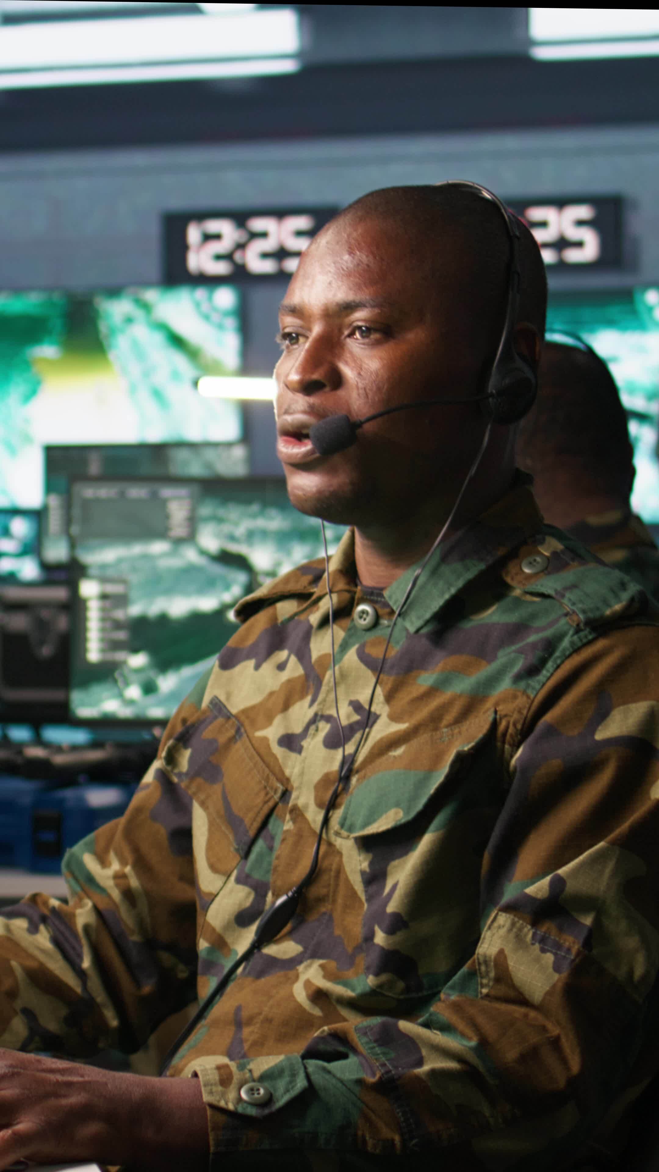 Vertical Army specialist working in war room operating surveillance tech, evaluating target data ...