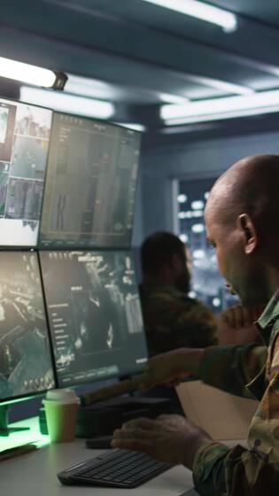 Vertical Army officers doing brainstorming in command center, looking at intel folder files ...