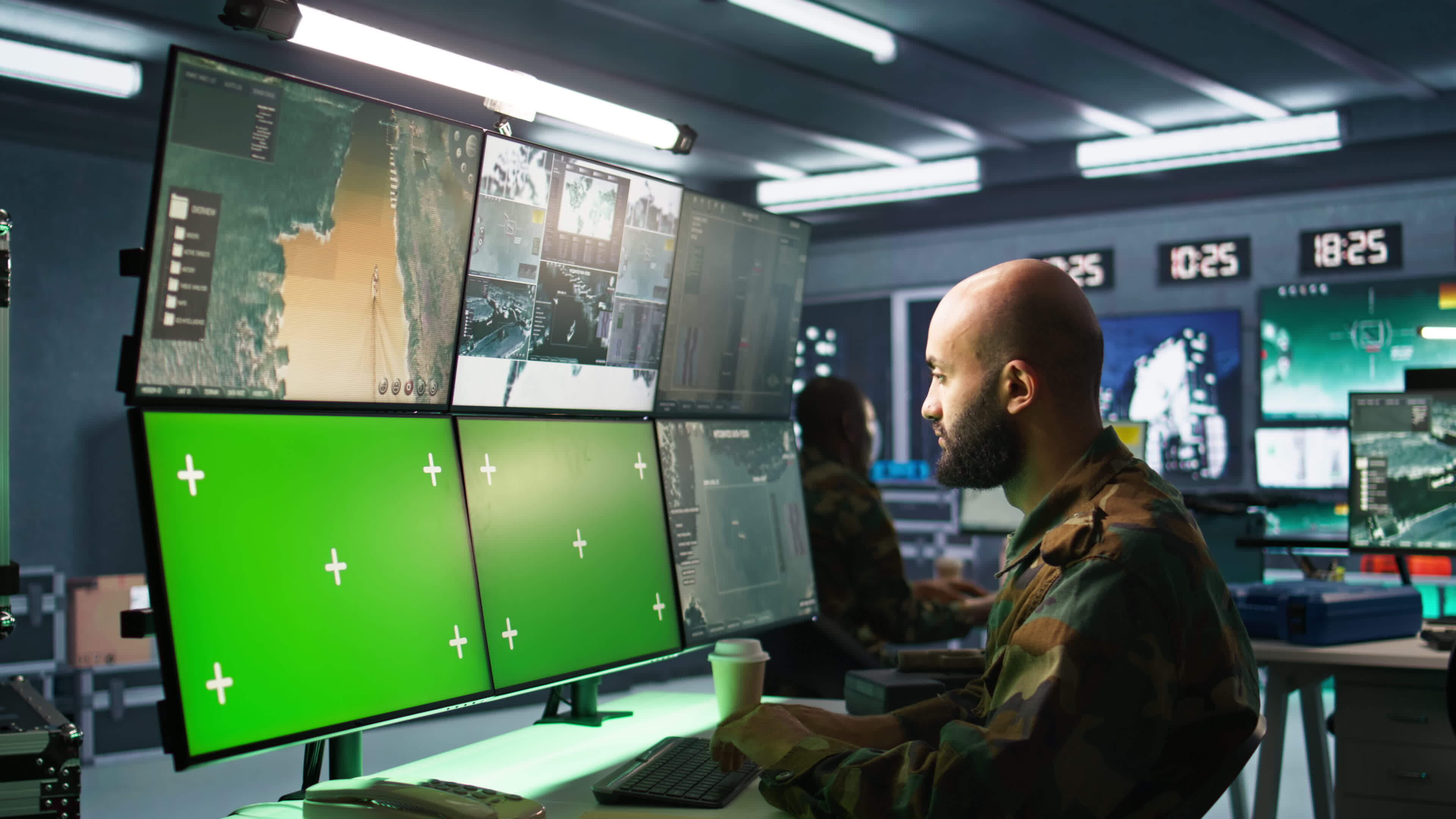 Army specialist working in war room operating surveillance tech, evaluating target data on green ...