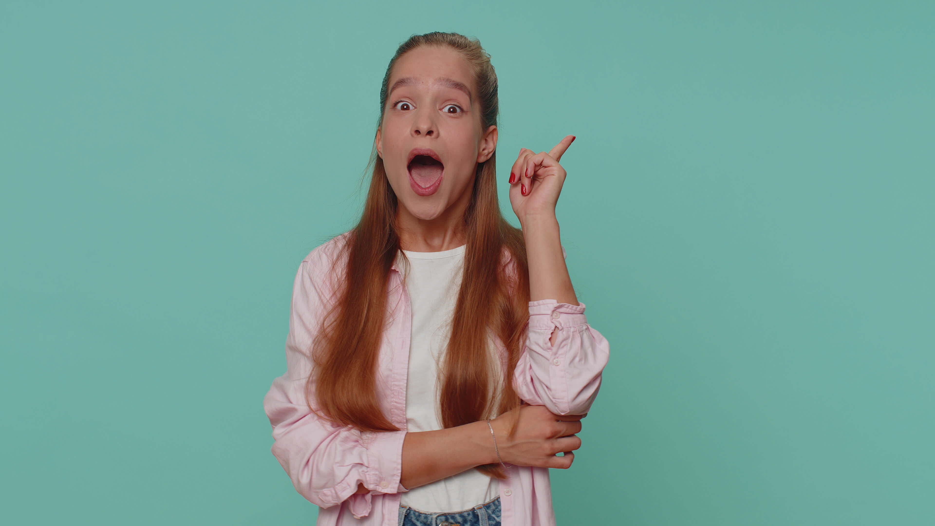 Inspired girl pointing finger up with open mouth, having good idea ...