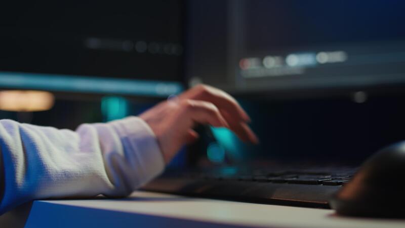 Programmer typing on computer to fix vulnerabilities in software enabling attackers to ...