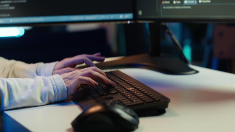 Programmer typing on computer to fix vulnerabilities in software enabling attackers to ...