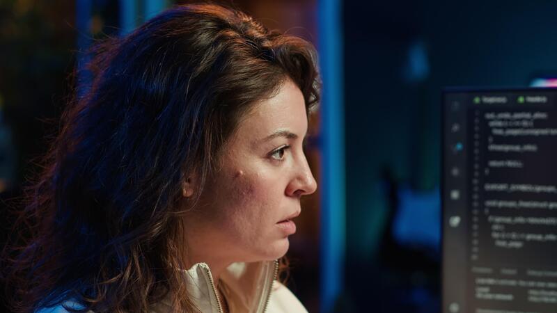 IT expert focused on looking for company security vulnerabilities and injected malware, close up ...