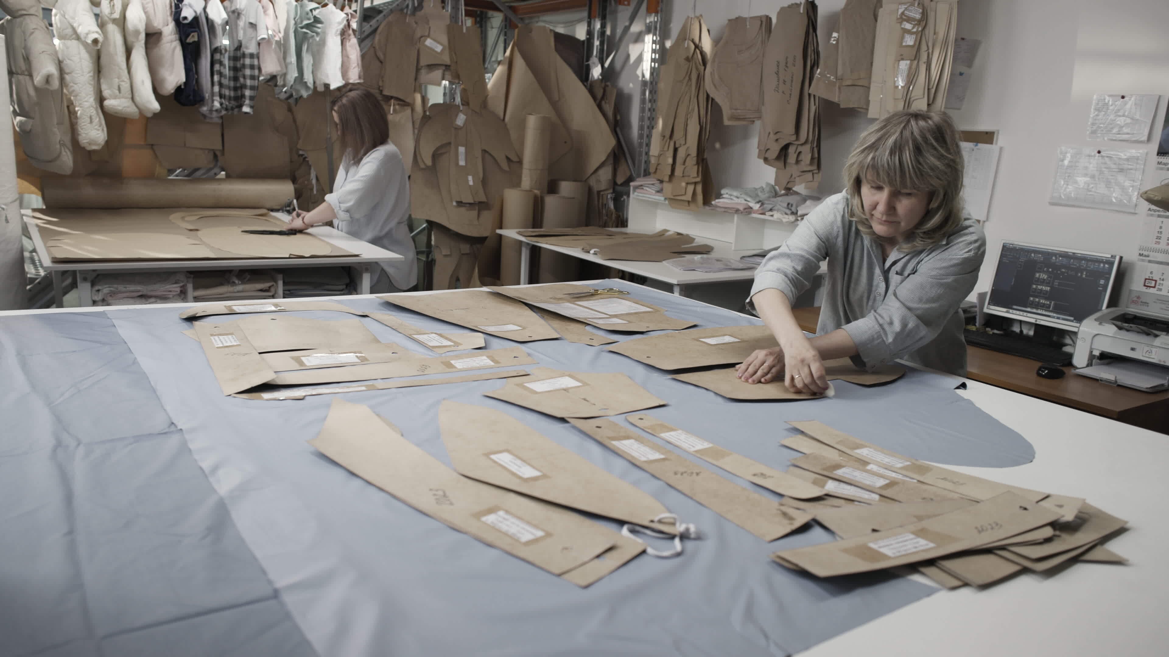 Tailors working on designing patterns and fabrics in a workshop with ...