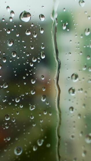 Water droplets background. Rain drops on a window pane. Water drop falling down on the window ...