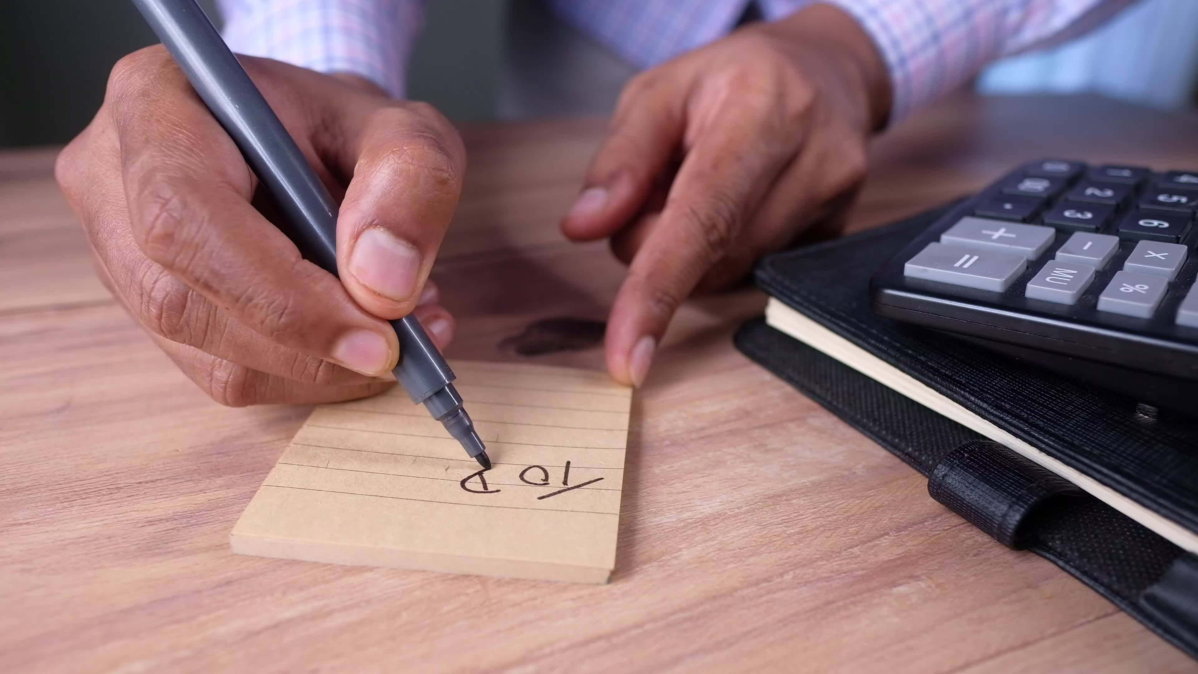 Man writing on notepad with pen and calculator 50012727 Stock Video at ...