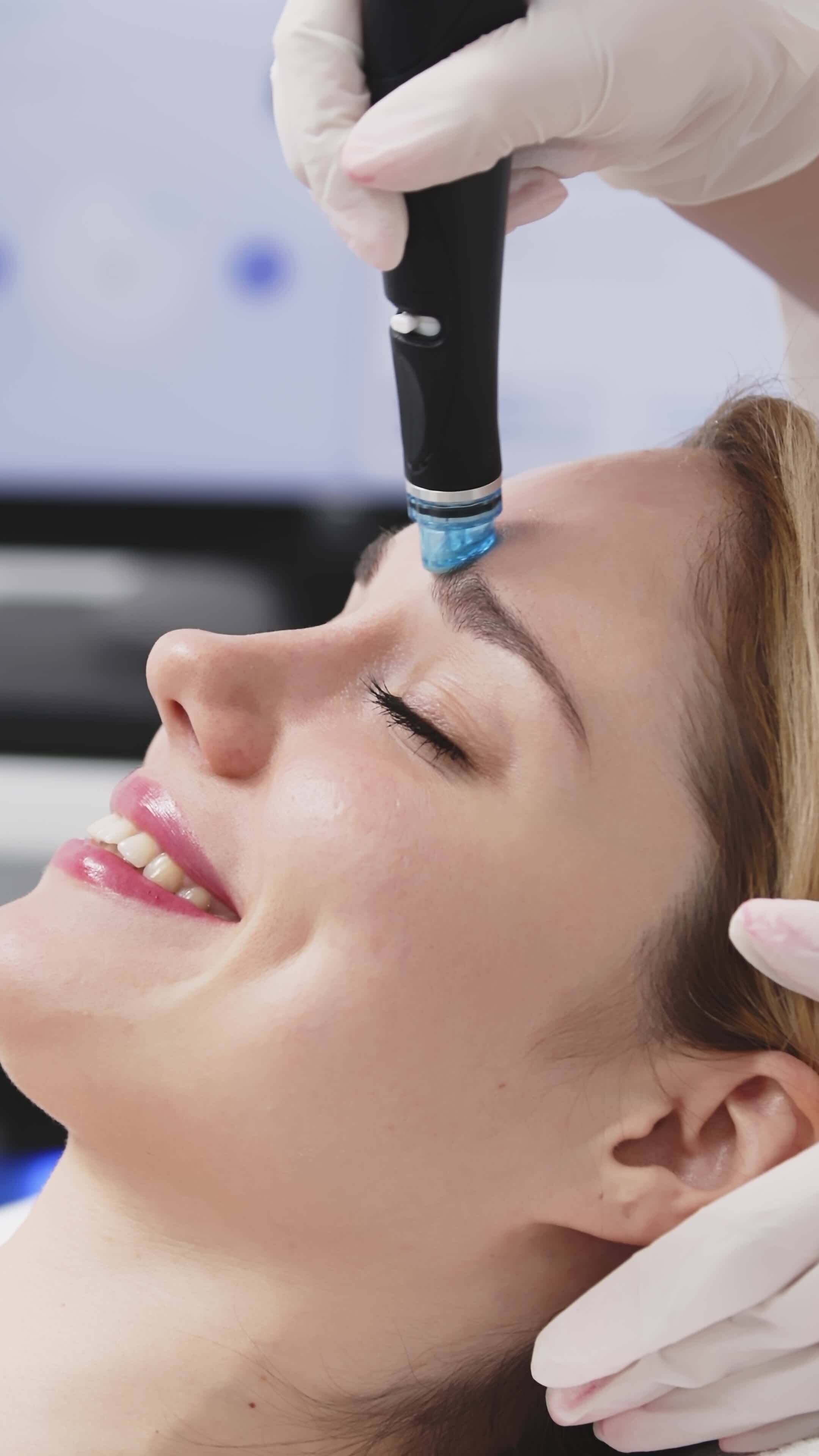 un profesional realiza un hidropeeling facial tratamiento en un mujer en un moderno clínica ...