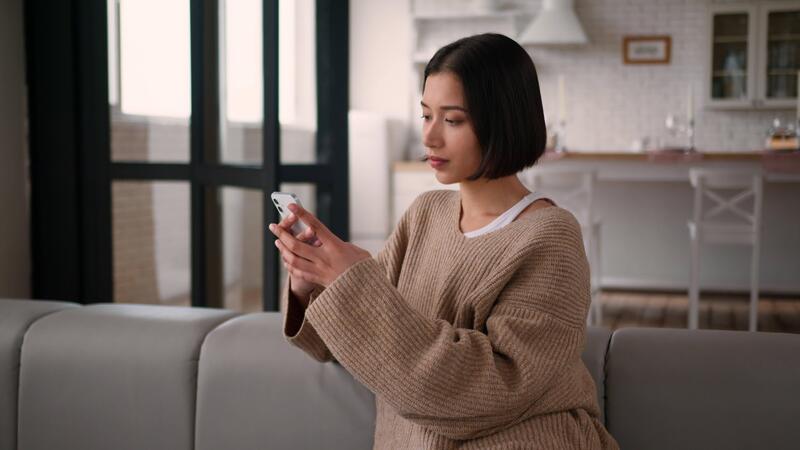 Hispanic latino woman happy girl female influencer homeowner tenant on home couch scrolling ...