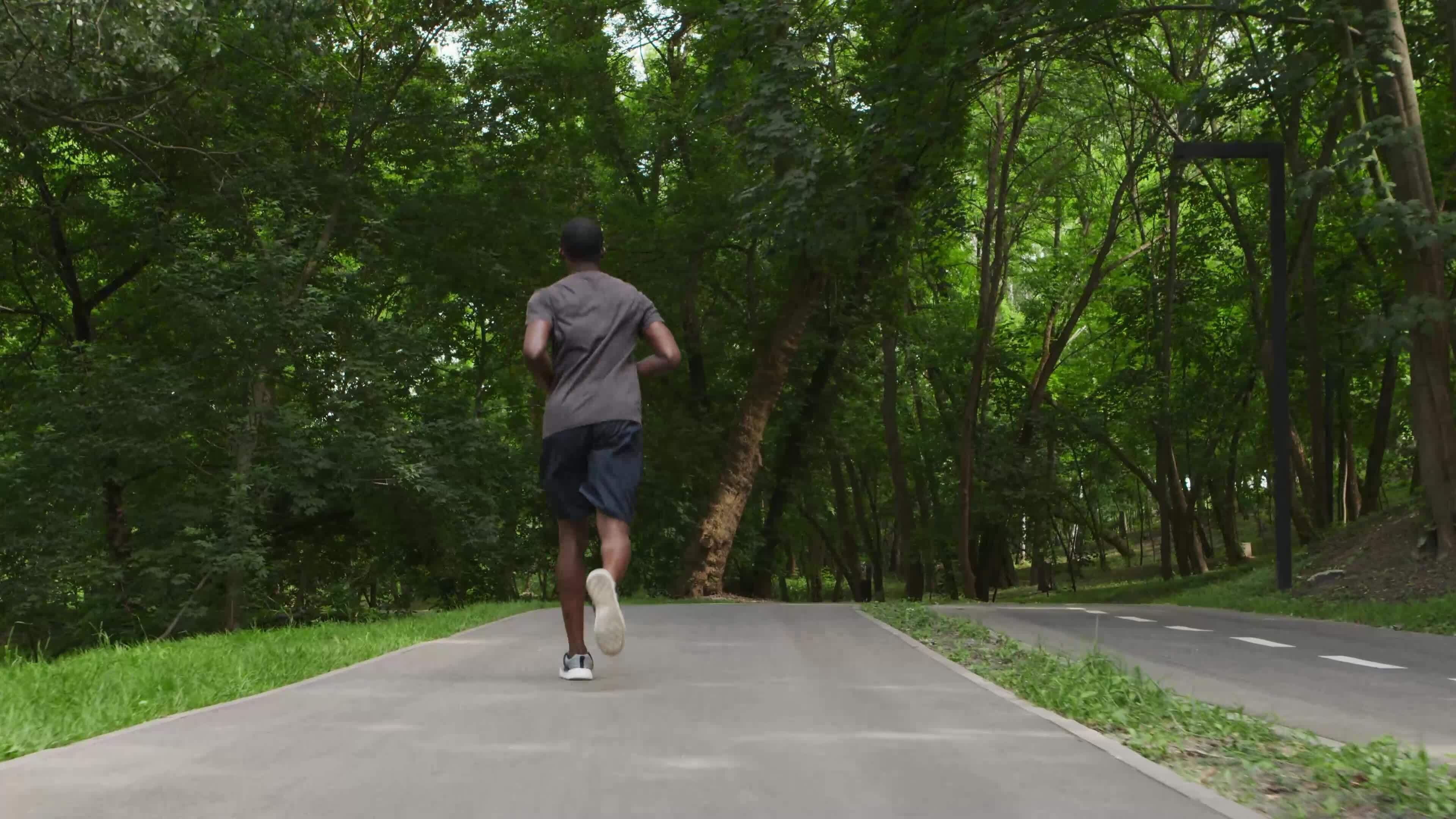 Physical training. Active african american guy running on port path in park, back view 50448291 ...