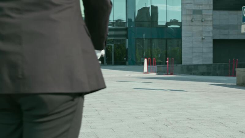 Middle Aged Man In Suit Riding Electric Scooter In City Tracking Shot