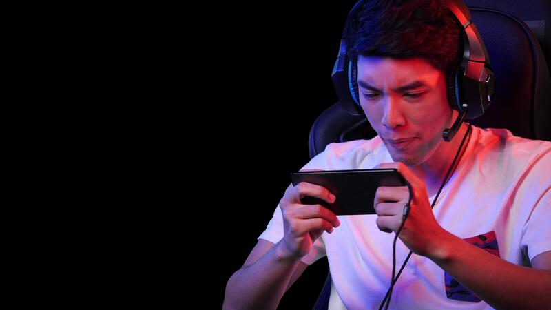 Focused Gamer Wearing Headset Immersed in Mobile Gaming. Young Man ... Focused Gamer Wearing Headset Immersed in Mobile Gaming. Young Man ...