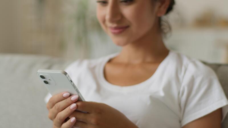 Happy smiling Indian woman using smartphone at home positive laugh Arabian girl female holding ...