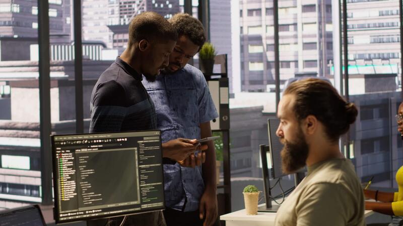 Machine Learning Infrastructure Technicians Using Tablet To Do Checkup On Algorithms That Enable