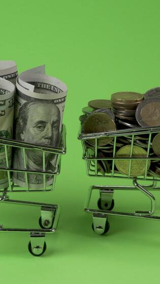 Small shopping carts filled with hundred dollar bills and coins are ...