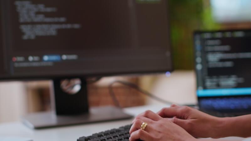 Asian programmer seen typing code for a user interface design on dual ... Asian programmer seen typing code for a user interface design on dual ...