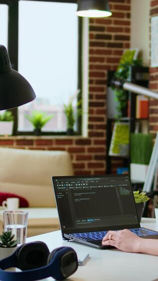 Vertical Professional asian software engineer is working remotely typing code on a laptop, using ...