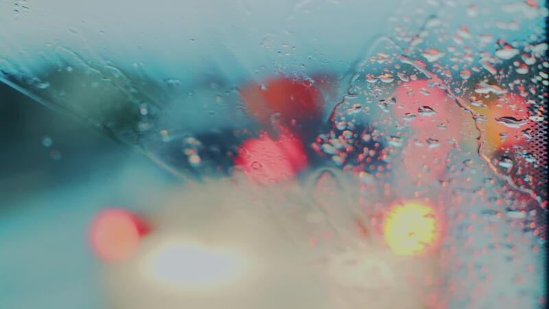 Rain drops over windshield. Abstract view of water drops through ...