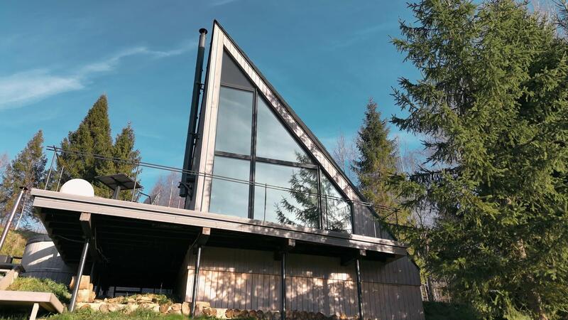 Contemporary A-frame cabin with large glass windows, nestled in a ...