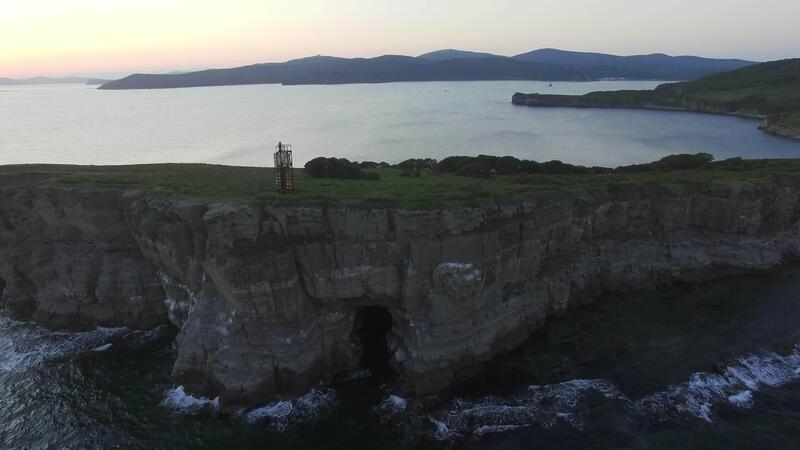 Aerial. Spectacular aerial view of rocky cape jutting into sea, with ... Aerial. Spectacular aerial view of rocky cape jutting into sea, with ...