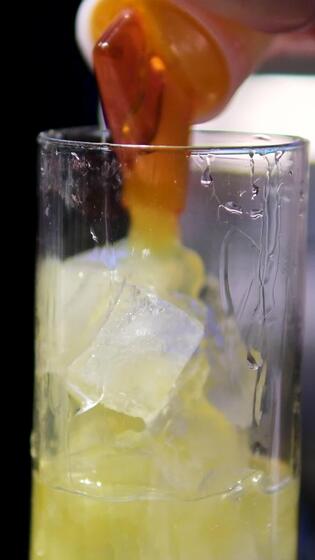 Making fresh summer cocktail. pouring carbonated water in glass with ice cubes. Slow motion ...