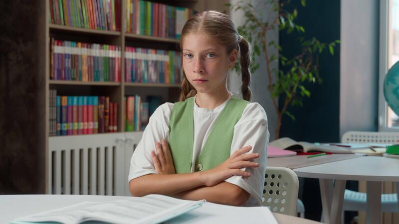 Sad tired offended Caucasian little girl school child kid pupil schoolgirl student primary ...