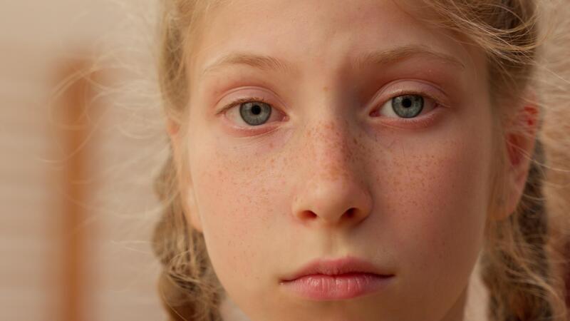 Sad upset kid face close up Caucasian girl teen child schoolgirl daughter teenager worried alone ...