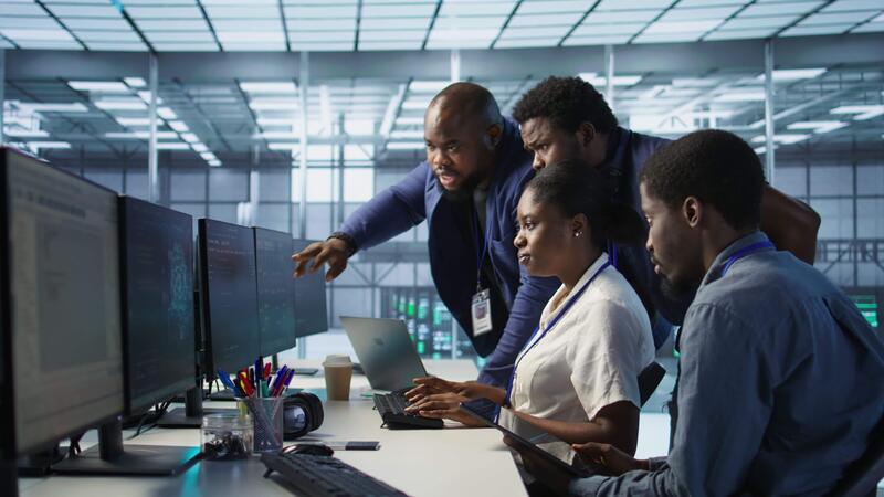 Team Of Data Center Technicians Maintaining Company Network Infrastructure By Configuring And