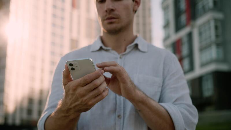 Close up Caucasian man using mobile phone smartphone social media smiling browsing scrolling ...
