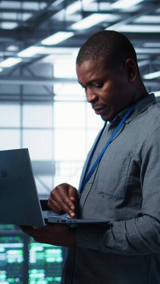 Vertical Colleagues In Data Center Workplace Use Laptop To Calibrate