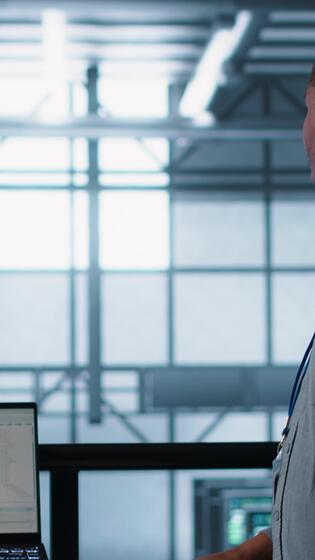 Vertical Teamworking Data Center Computer Scientists Using Artificial Intelligence On Laptop And