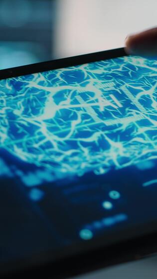 Vertical Close up of computer scientist in data center uses AI on tablet, verifying compliance ...