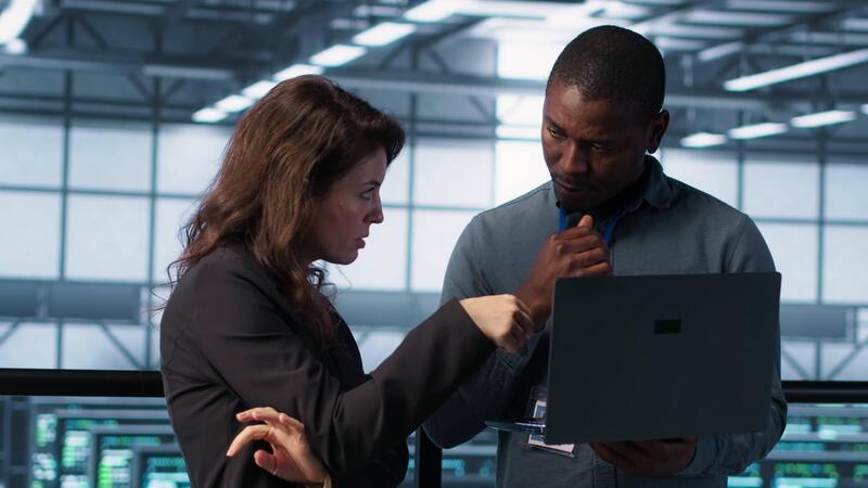 Developers in data center workspace coding on laptop, analyzing metrics ... Developers in data center workspace coding on laptop, analyzing metrics ...