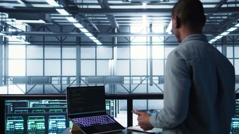 Technician In Data Center Using Ai On Laptop And Tablet Developing Disaster Recovery Plans