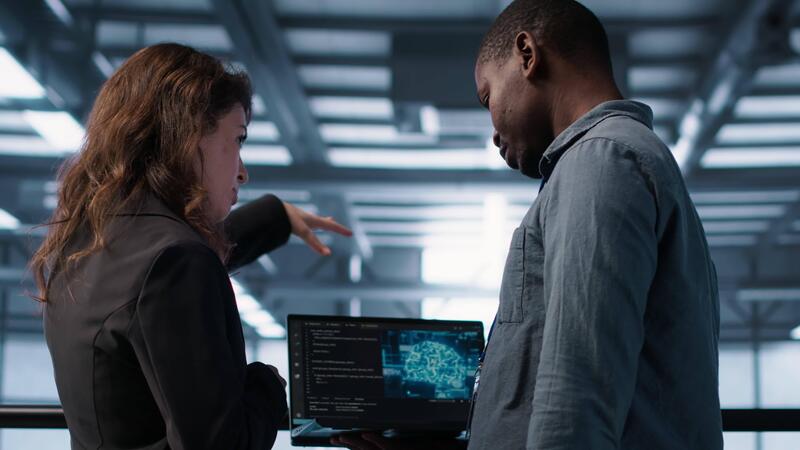 Software developers in data center using laptop, employing AI machine learning models. Workers ...