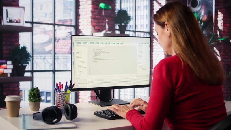 Mature woman interacting with a virtual assistant on her computer at ...