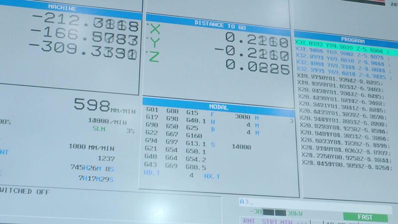 Close up a CNC machine control panel displaying real time tech ...