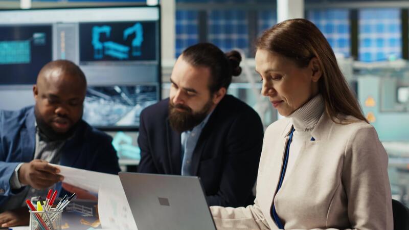 Factory manager looking over paperwork files, developing business model, expanding production ...