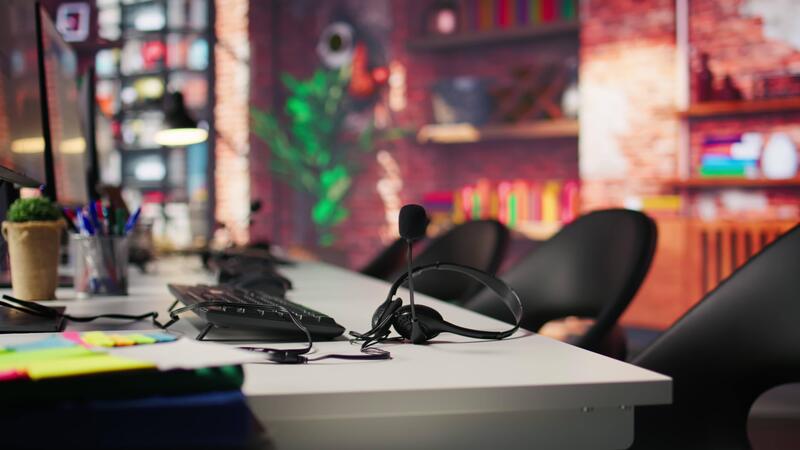Multiple computer monitors in empty office displaying analytics dashboards and data charts ...