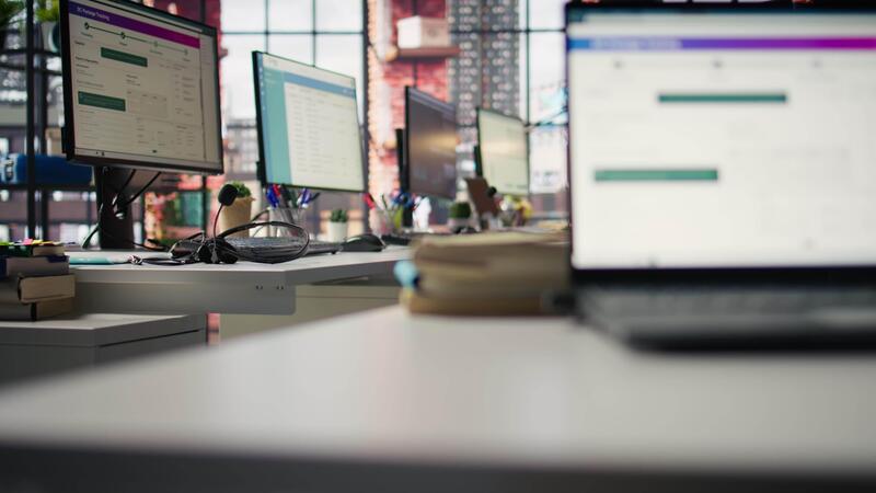 Computer monitors on office desk showing data analytics dashboards and performance charts. PC ...