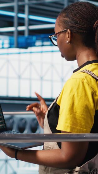 Vertical Engineers working in smart factory, collecting and analyzing data. Technicians using ...