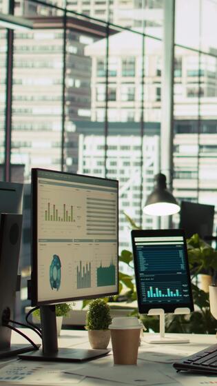 Vertical Financial charts and KPI metrics on displays in office, panning shot. Vibrant and ...