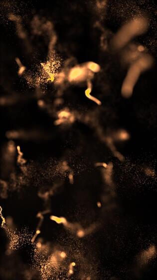 Abstract background with exploding glittering shiny gold particles and shallow depth of field ...