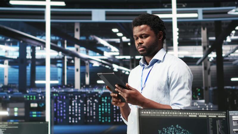 Vertical Data center technician using tablet to do node tree programming, optimizing resource ...