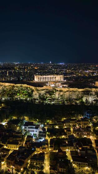 Aerial timelapse of Athens city skyline at night with the illuminated Acropolis, Parthenon ...