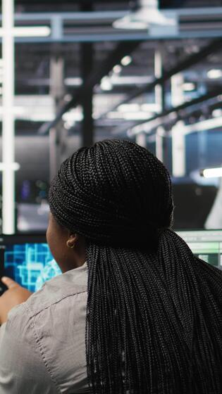 Vertical Data center manager supervising worker deploying AI solutions optimizing equipment ...